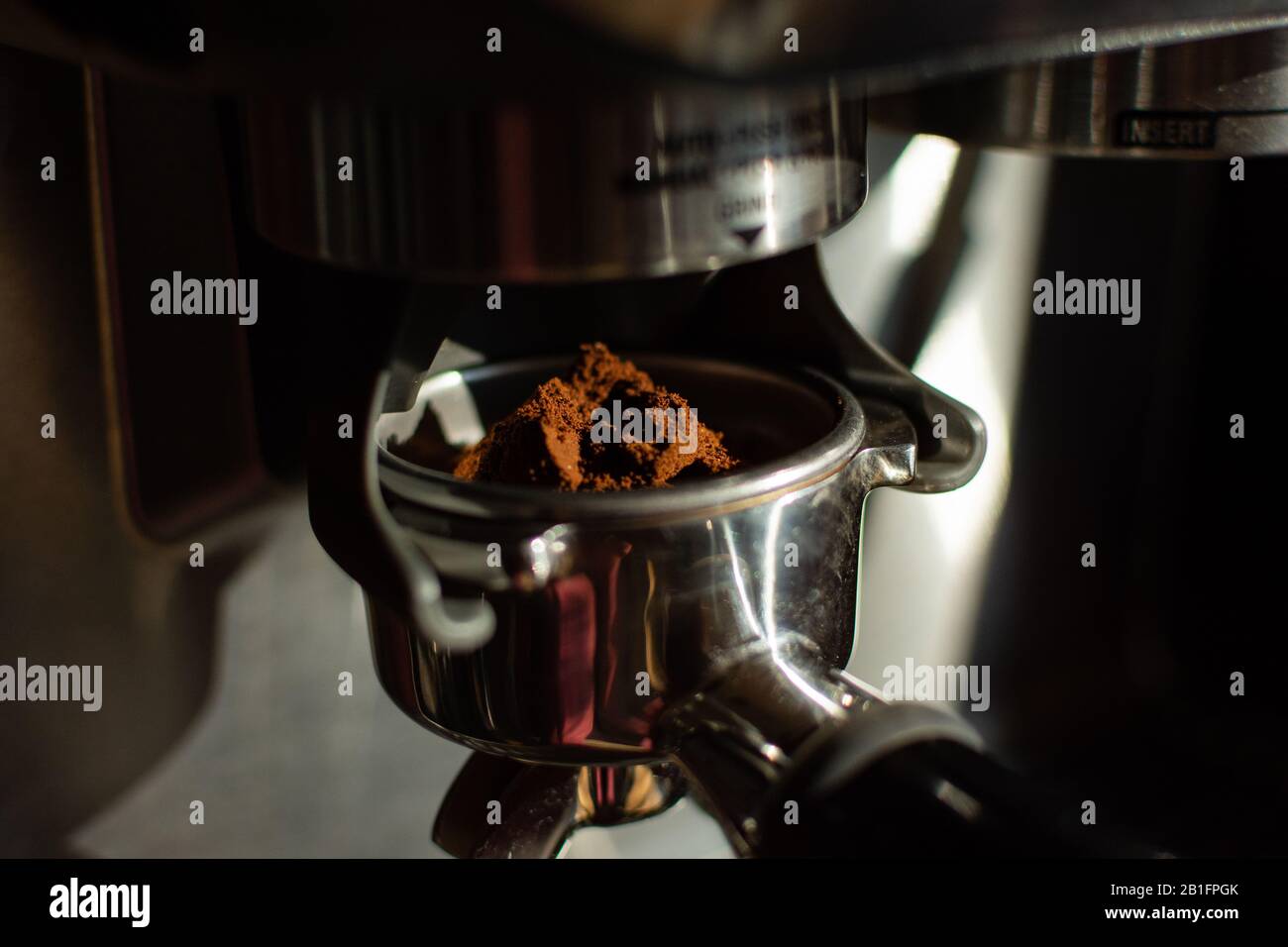 Espresso Machine grinding coffe beans into filter. machine ground coffe ...