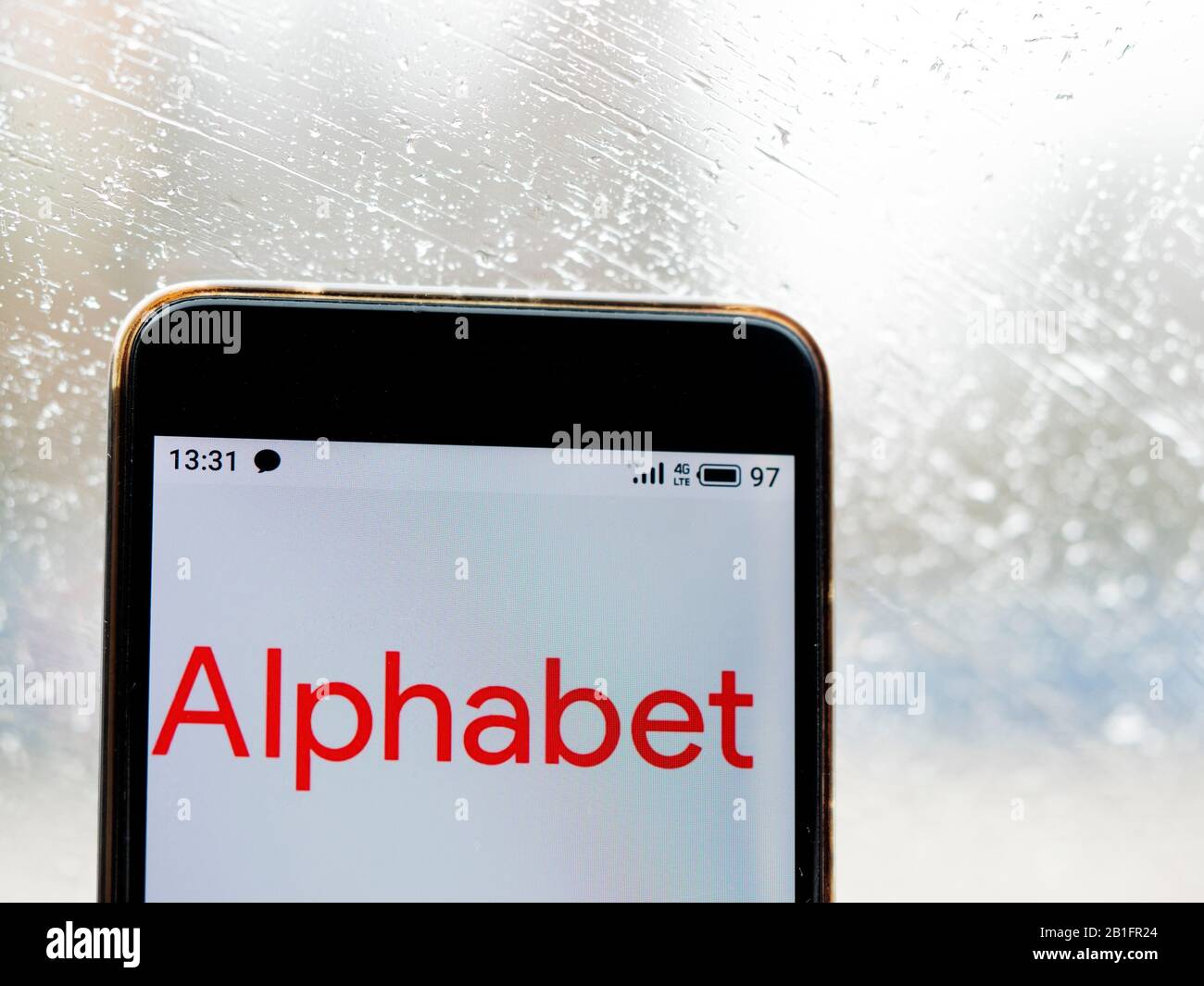 In this photo illustration the Alpabet logo is seen displayed on a ...