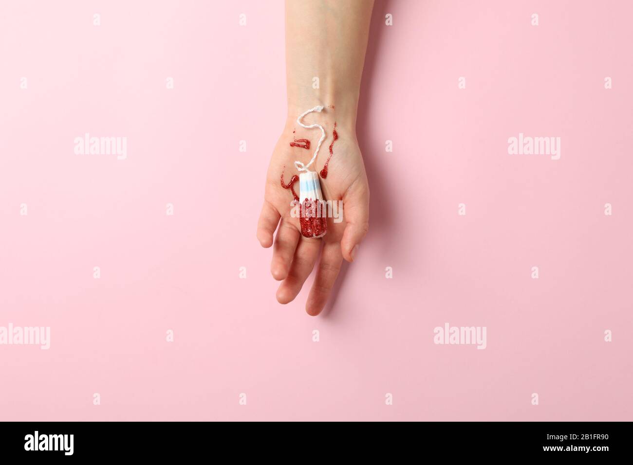Female hand holding used tampon on pink background, space for text ...