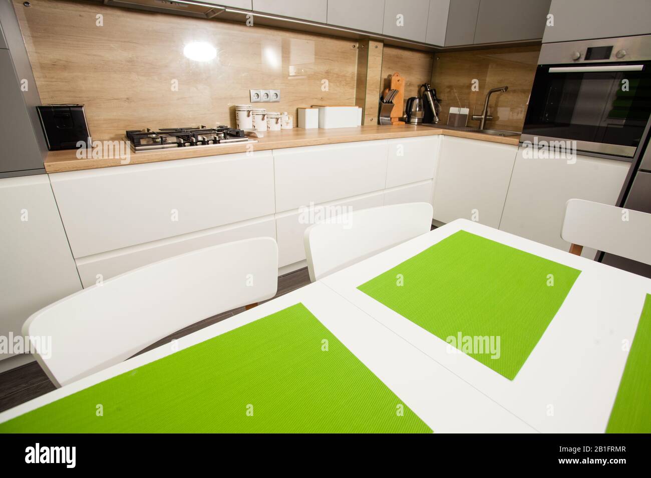 Empty white dining table with green details at kitchen Stock Photo - Alamy