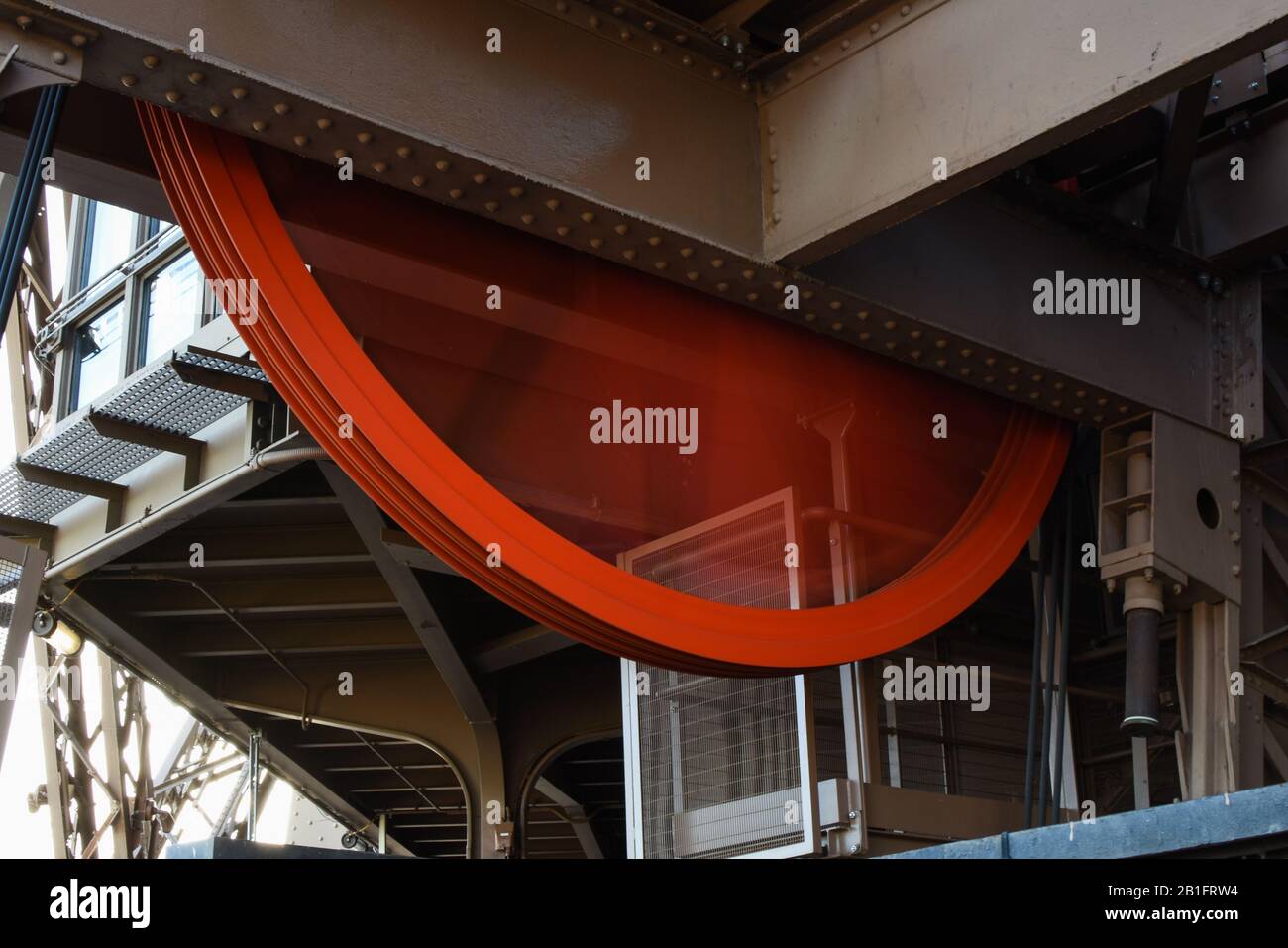 Red metal wheel of eiffel tower elevator rotating Stock Photo - Alamy