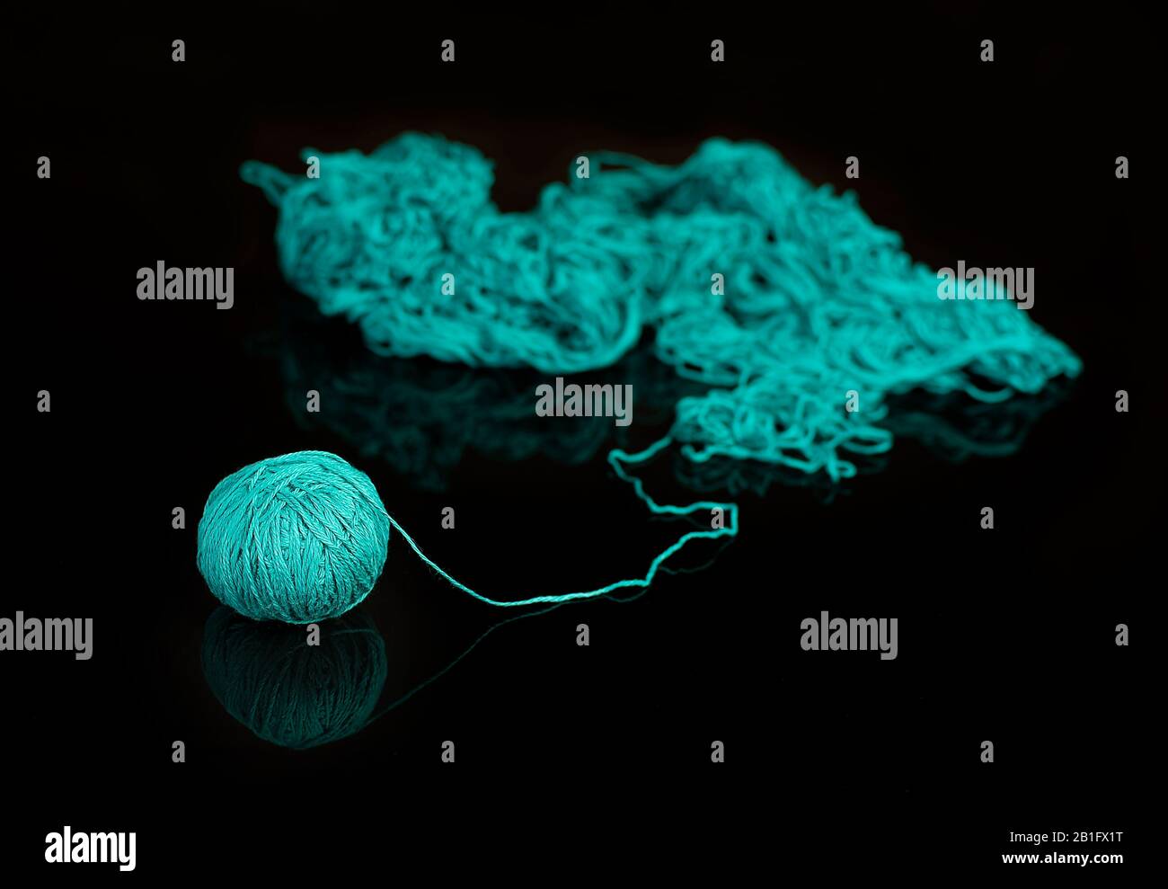 Pile of tangled yarn with a ball on the end leading out. The concept of ...