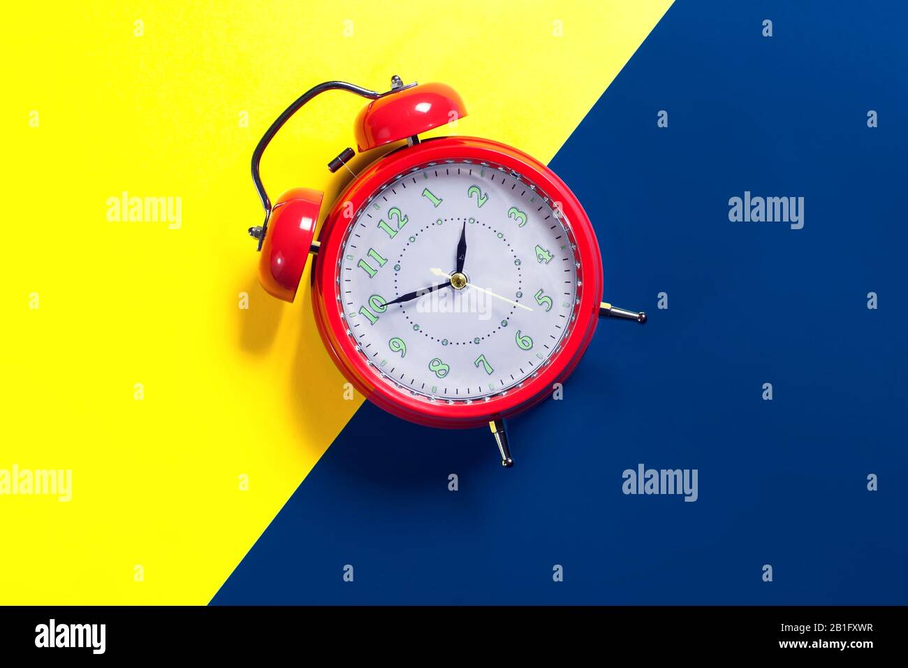 Red alarm clock is on color background. Time concept Stock Photo - Alamy
