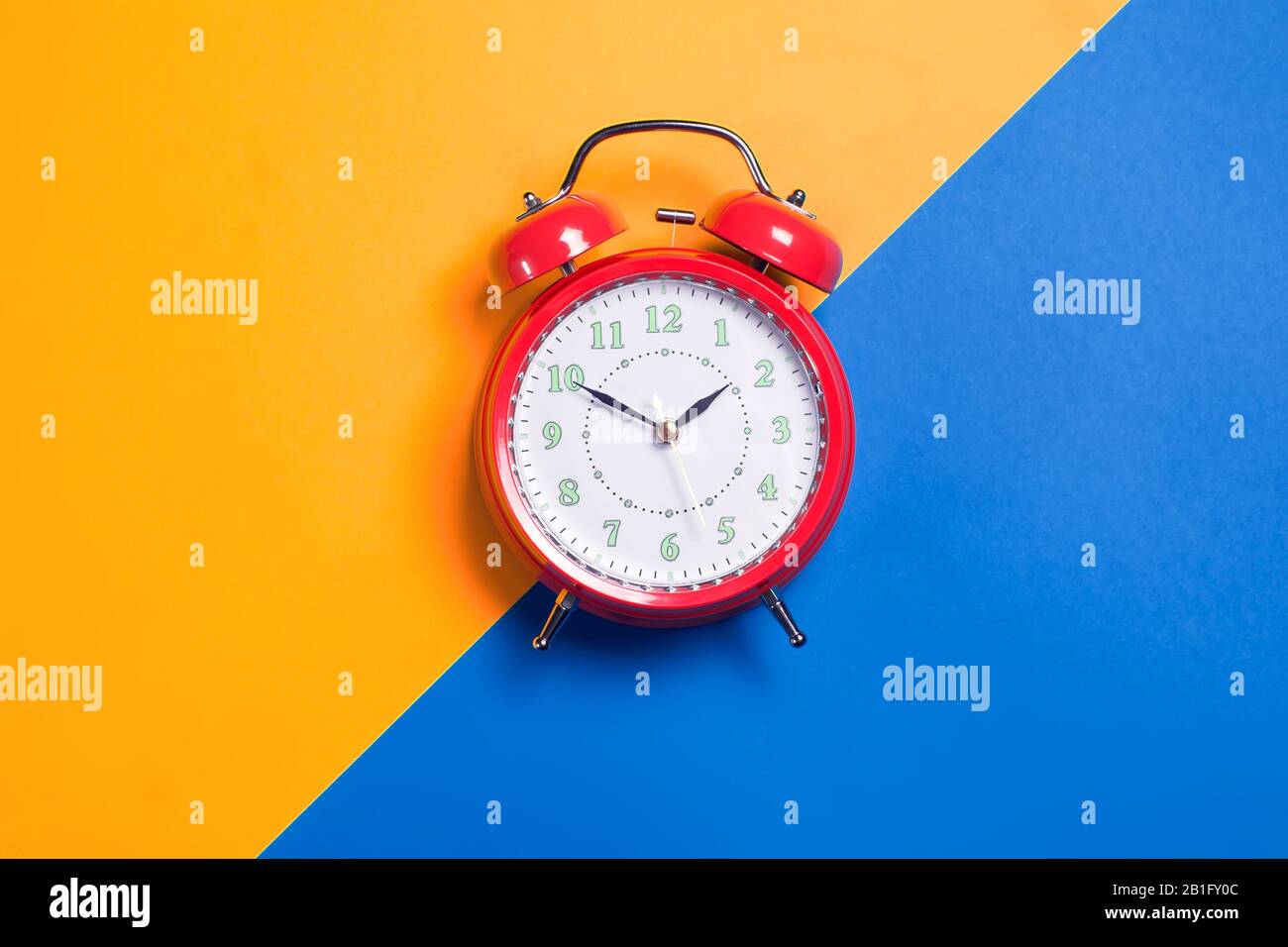 Red alarm clock is on color background. Time concept Stock Photo - Alamy