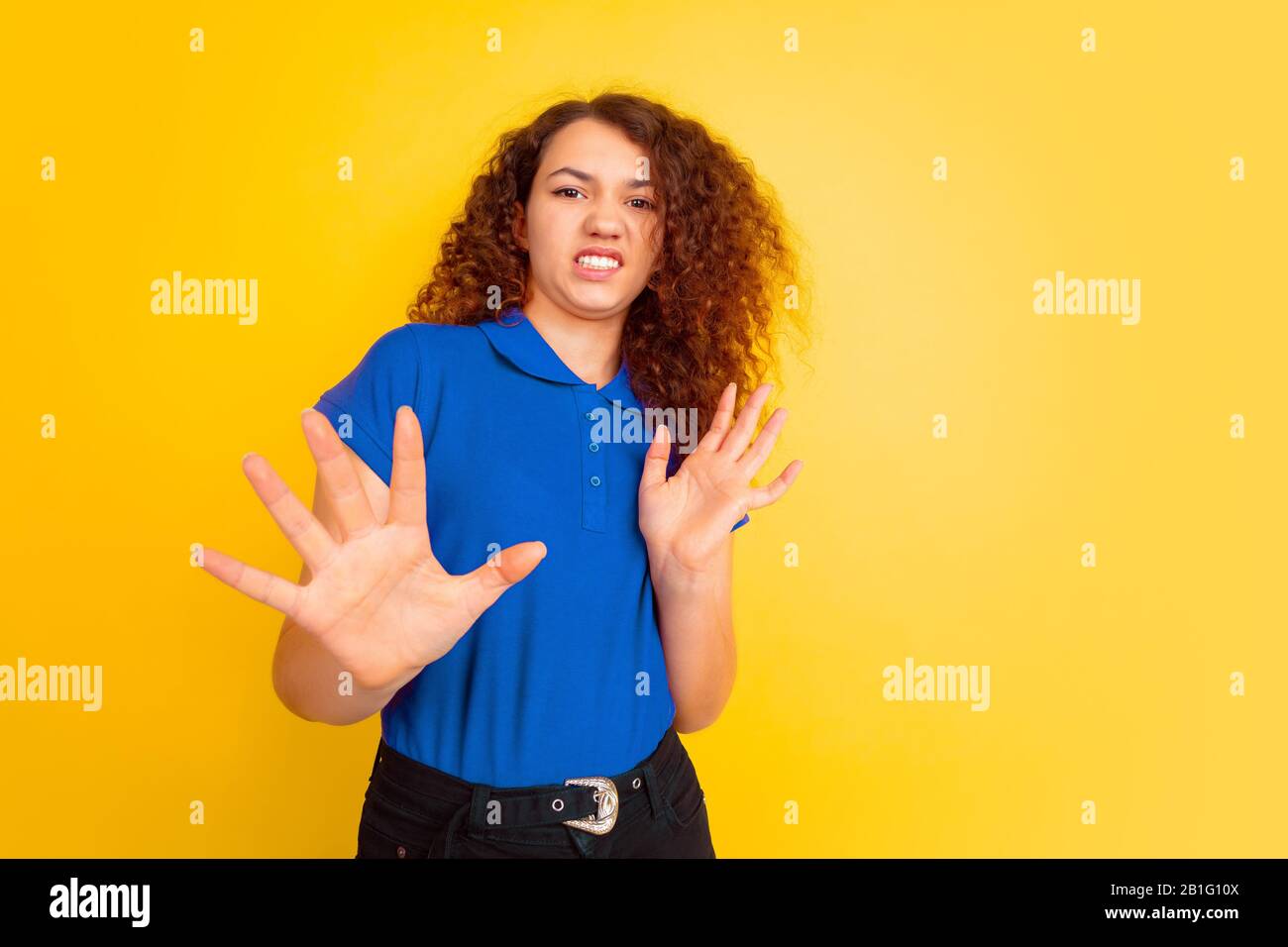 Rejection, disguasted. Caucasian teen's girl portrait on yellow studio ...