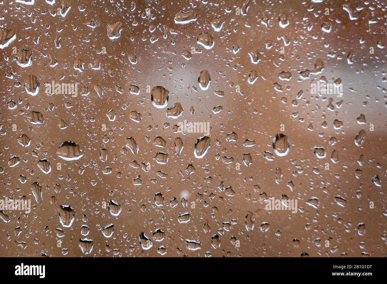 Raindrops on a glass window with house windows blurred Stock Photo - Alamy