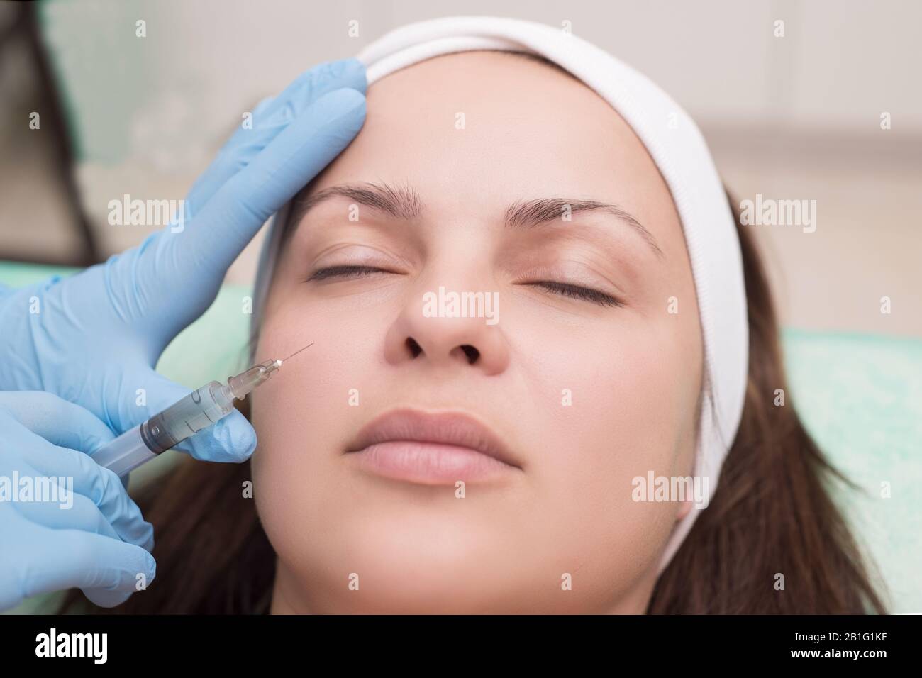 injection into the skin of the face of a young woman, close-up ...