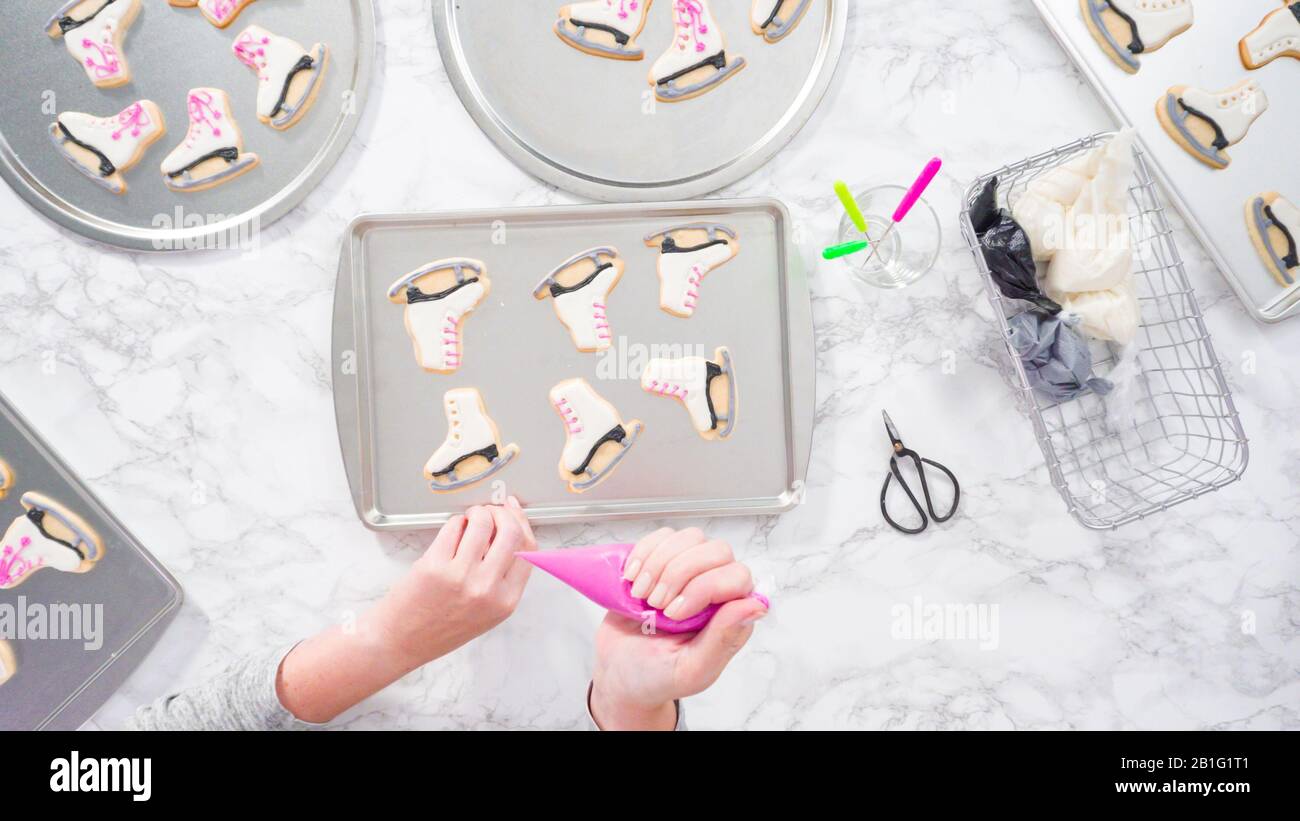 Flat lay. Icing figure skate shaped sugar cookies with royal icing ...