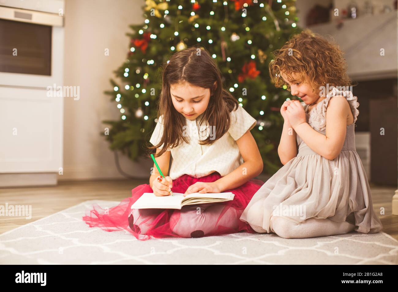 Two cute little sisters writing a letter to Santa Stock Photo - Alamy
