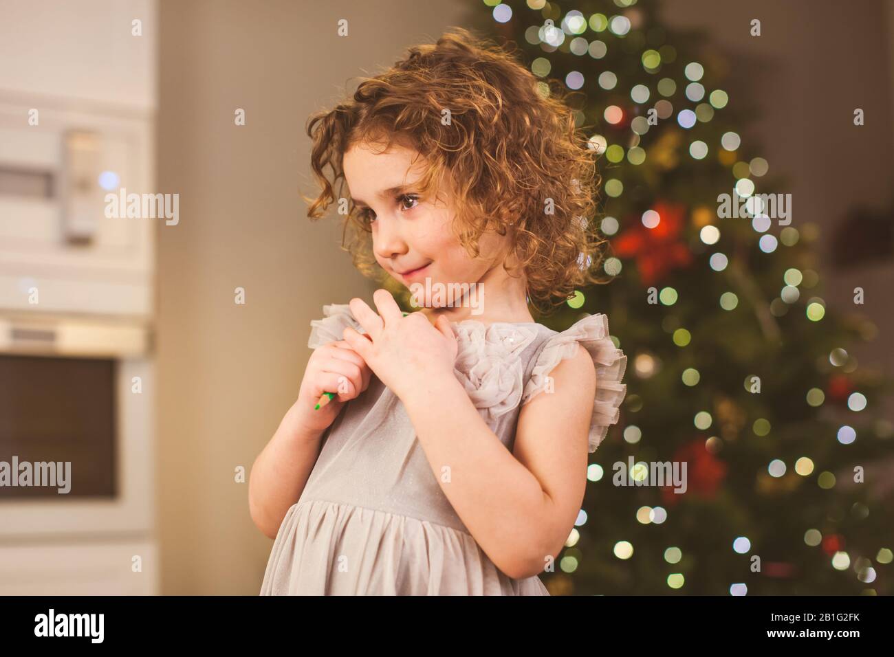 Cute girl in grey dress on New Year eve Stock Photo - Alamy