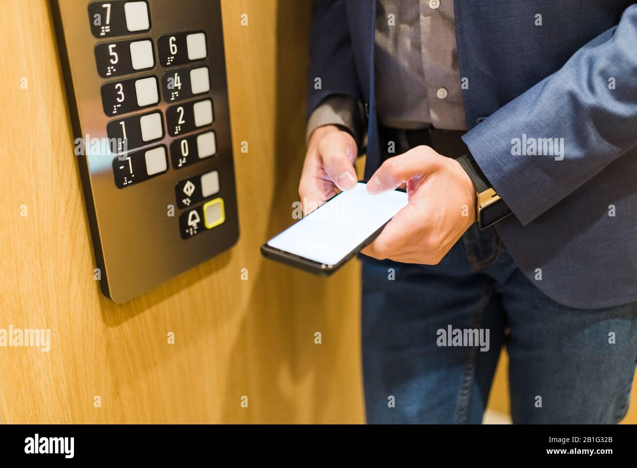 Unrecognizable businessman using mobile phone in elevator Stock Photo ...