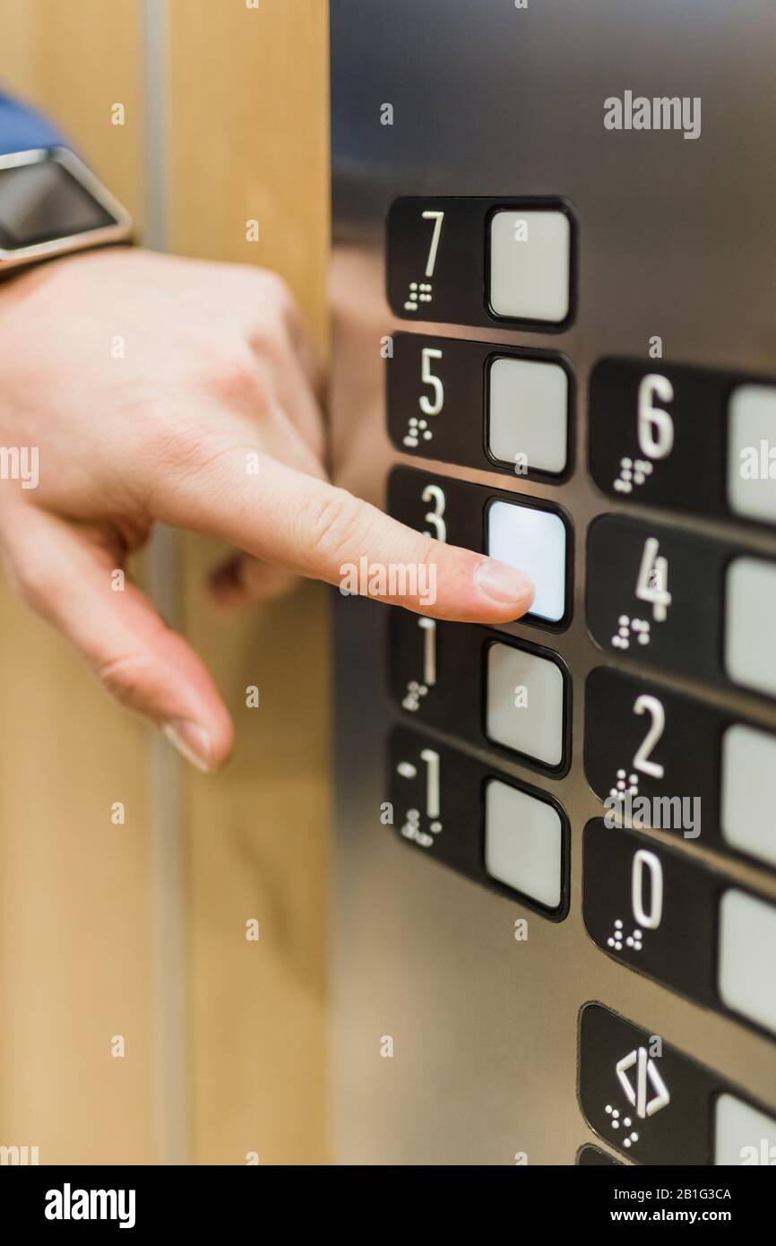 Close up of businessman pressing third floor control panel button in ...