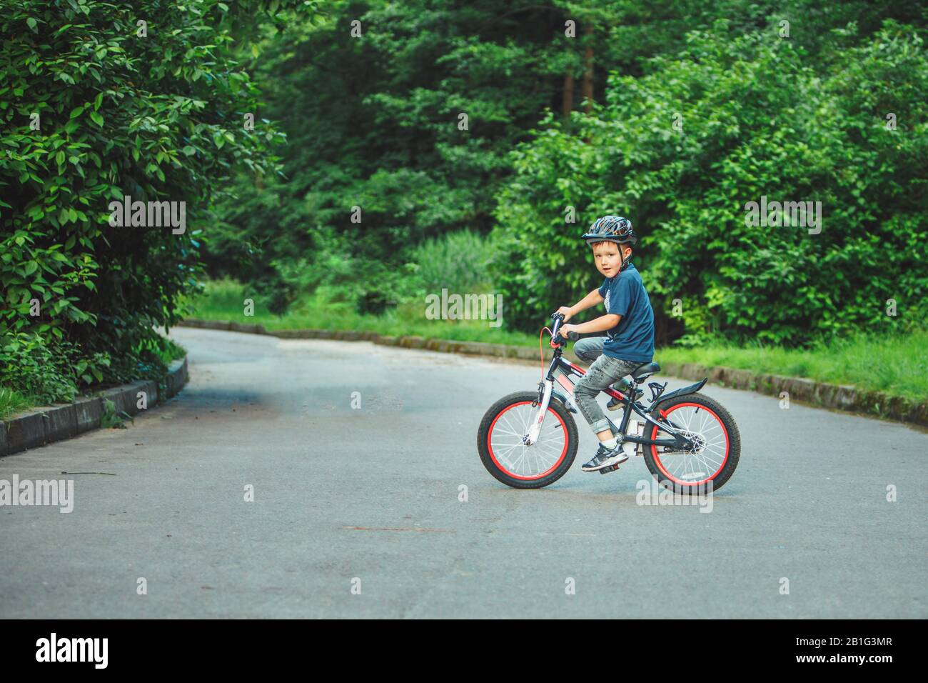 little boy riding on bicycle in helmet Stock Photo - Alamy