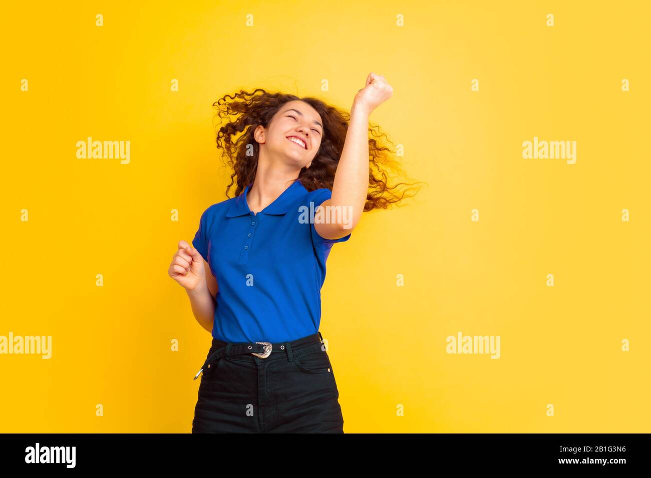 Dancing with flying hair. Caucasian teen's girl portrait on yellow ...