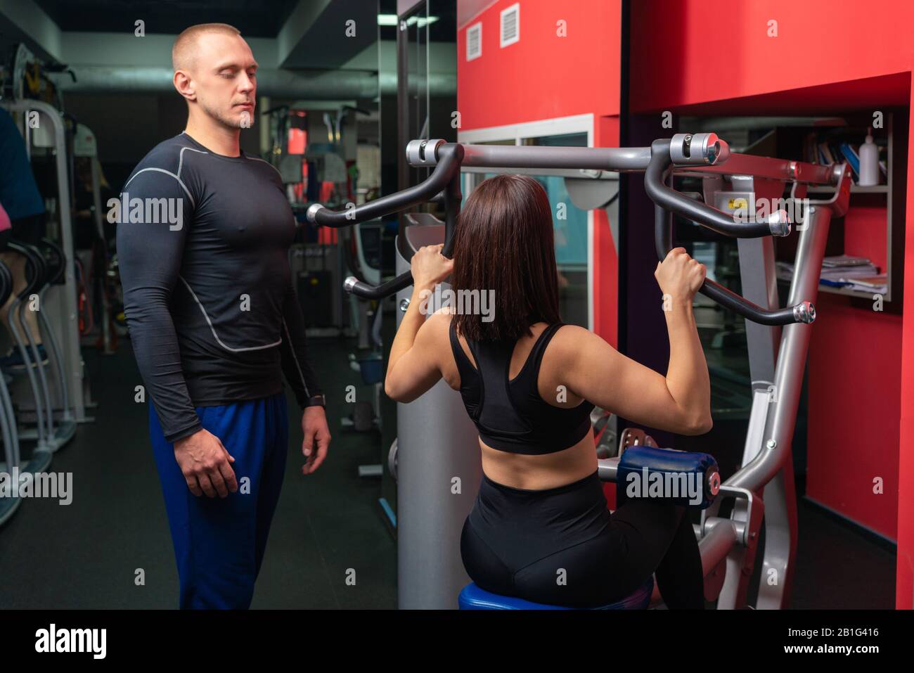 personal trainer man working with young woman in modern gym Stock Photo ...
