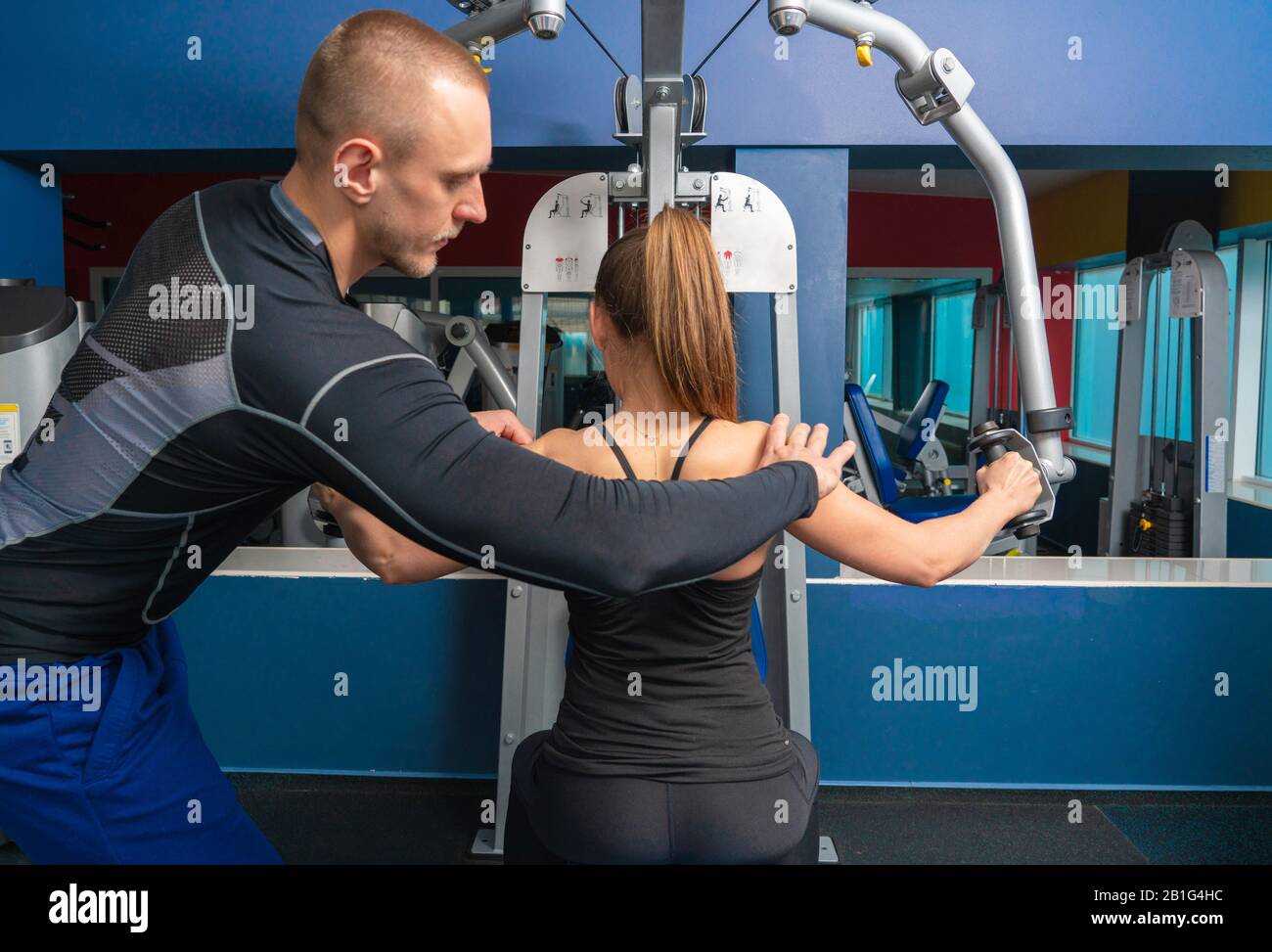 personal trainer man working with young woman in modern gym Stock Photo ...