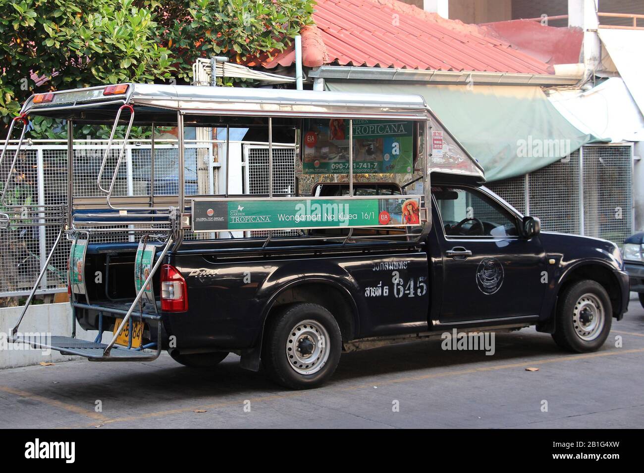 A Songthaew - a pick-up truck with bench seating along the sides, which ...