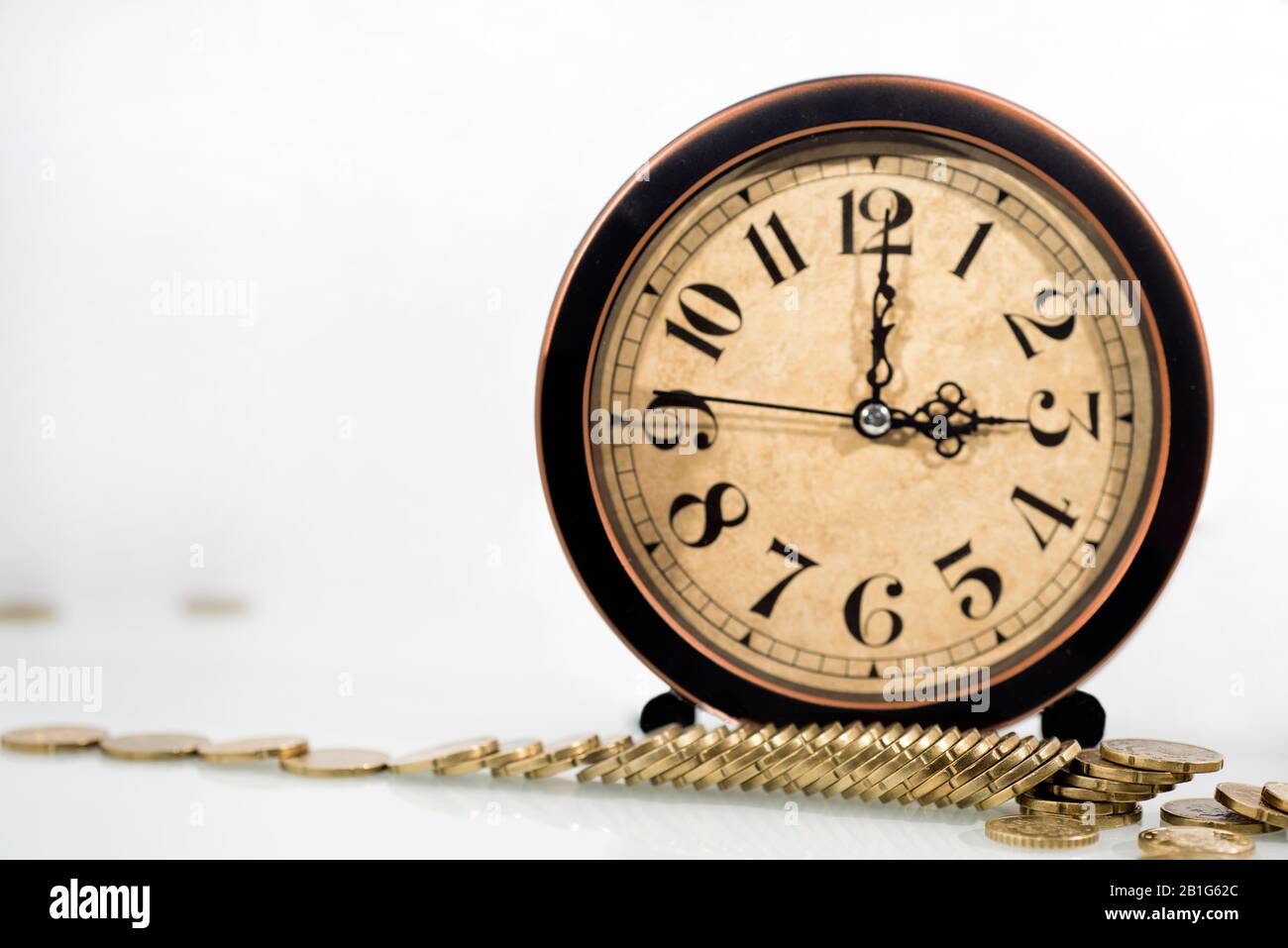 TIME IS MONEY concept: Alarm clock and with coins Stock Photo - Alamy