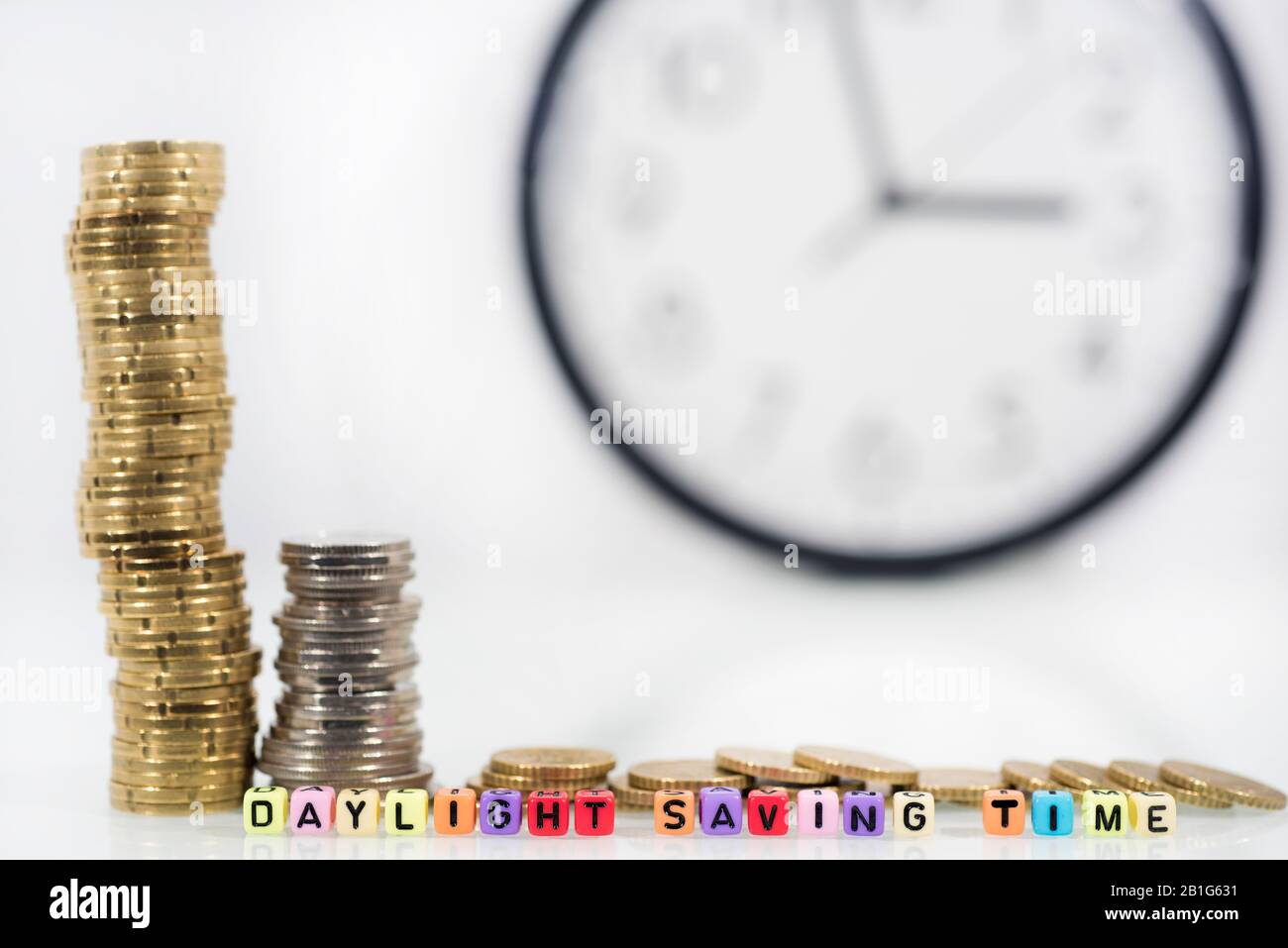 Coins with clock on white table. Summer Daylight Saving Time (DST ...