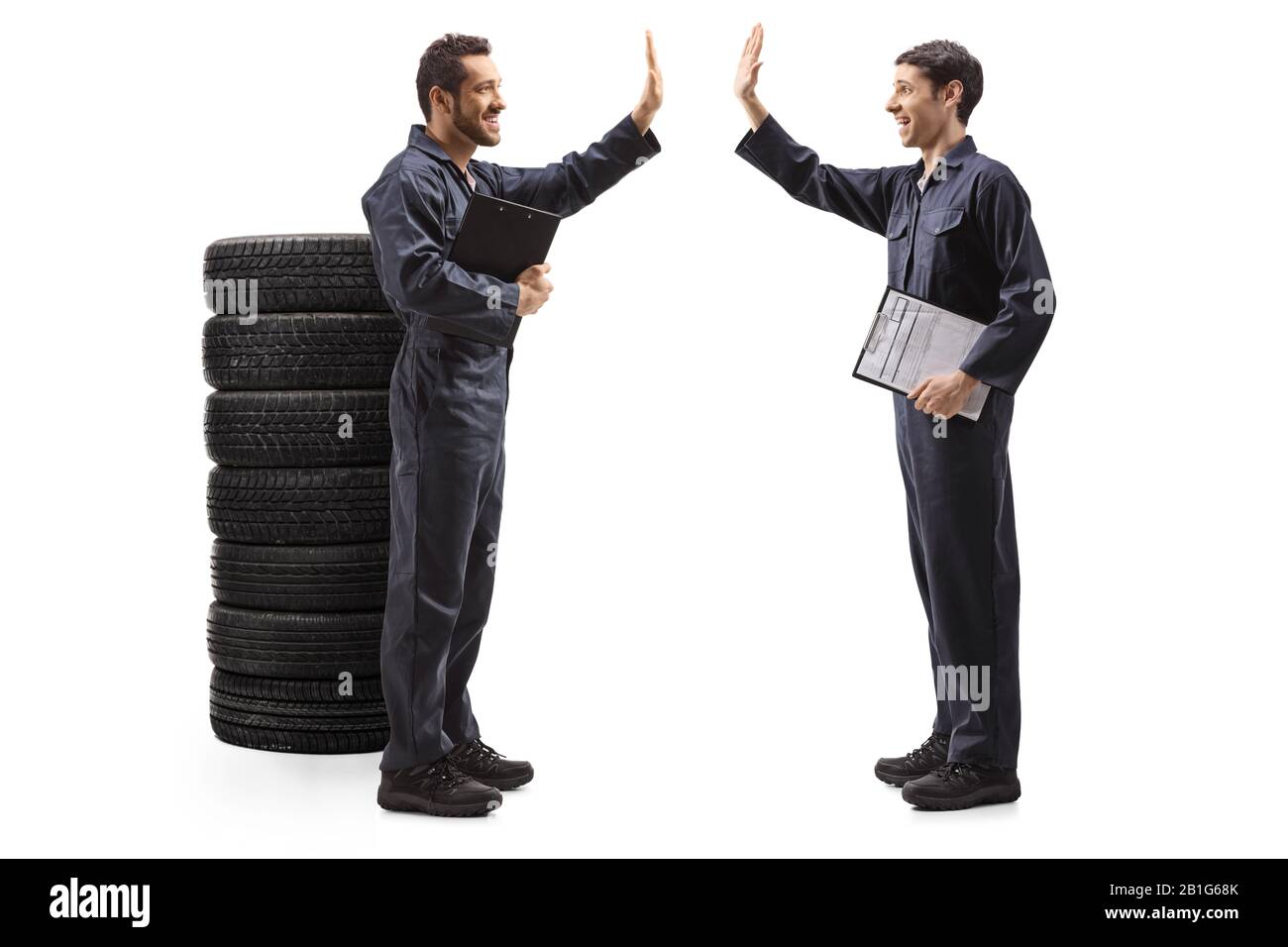 Full length profile shot of a two mechanic workers gesturing high five ...