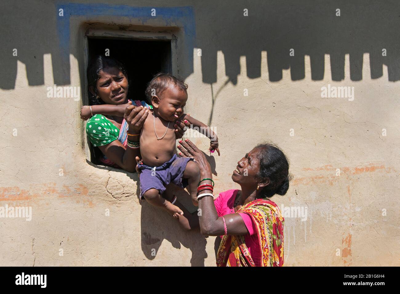 The image of Mother passing child to Grand mother in Purulia village ...