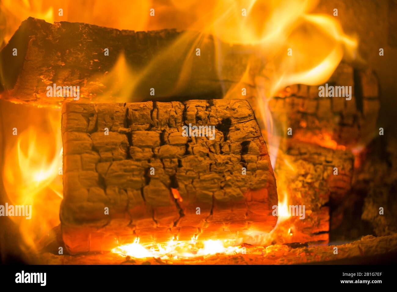 Logs burning in a wood burning stove Stock Photo - Alamy