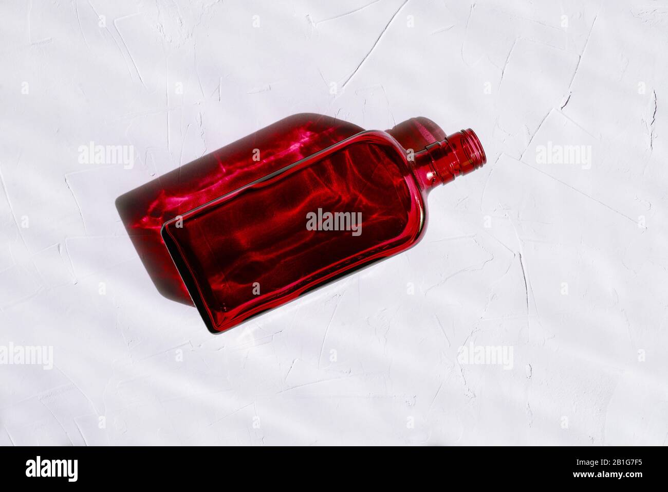 Glass bottle of red color on a white background. Empty open bottle of ...