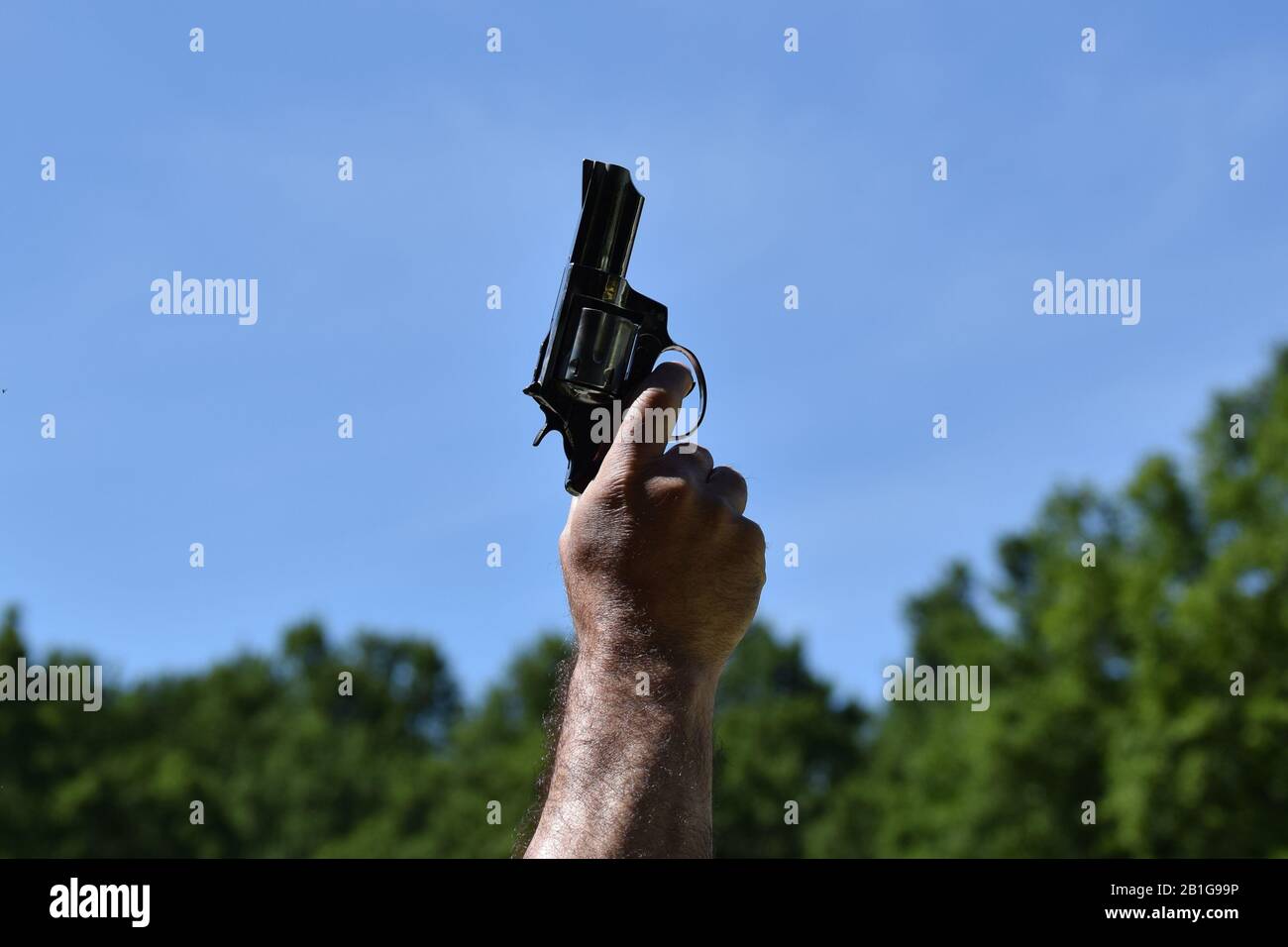 A man pointing to a clear blue sky with a gun before starting an ...