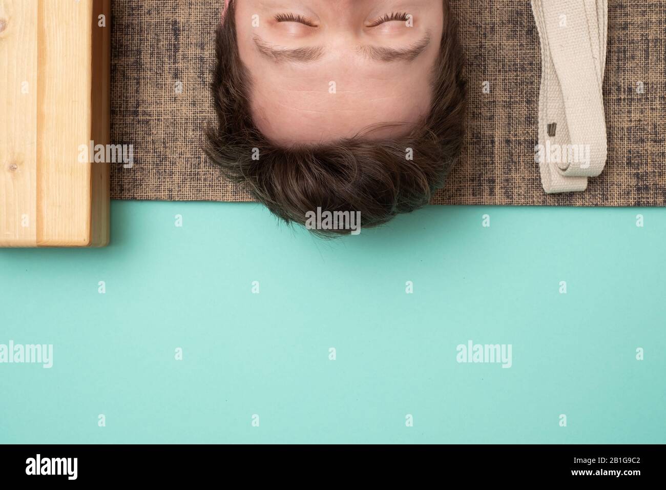 Young sporty man lying in Dead Body exercise or Corpse pose with his ...