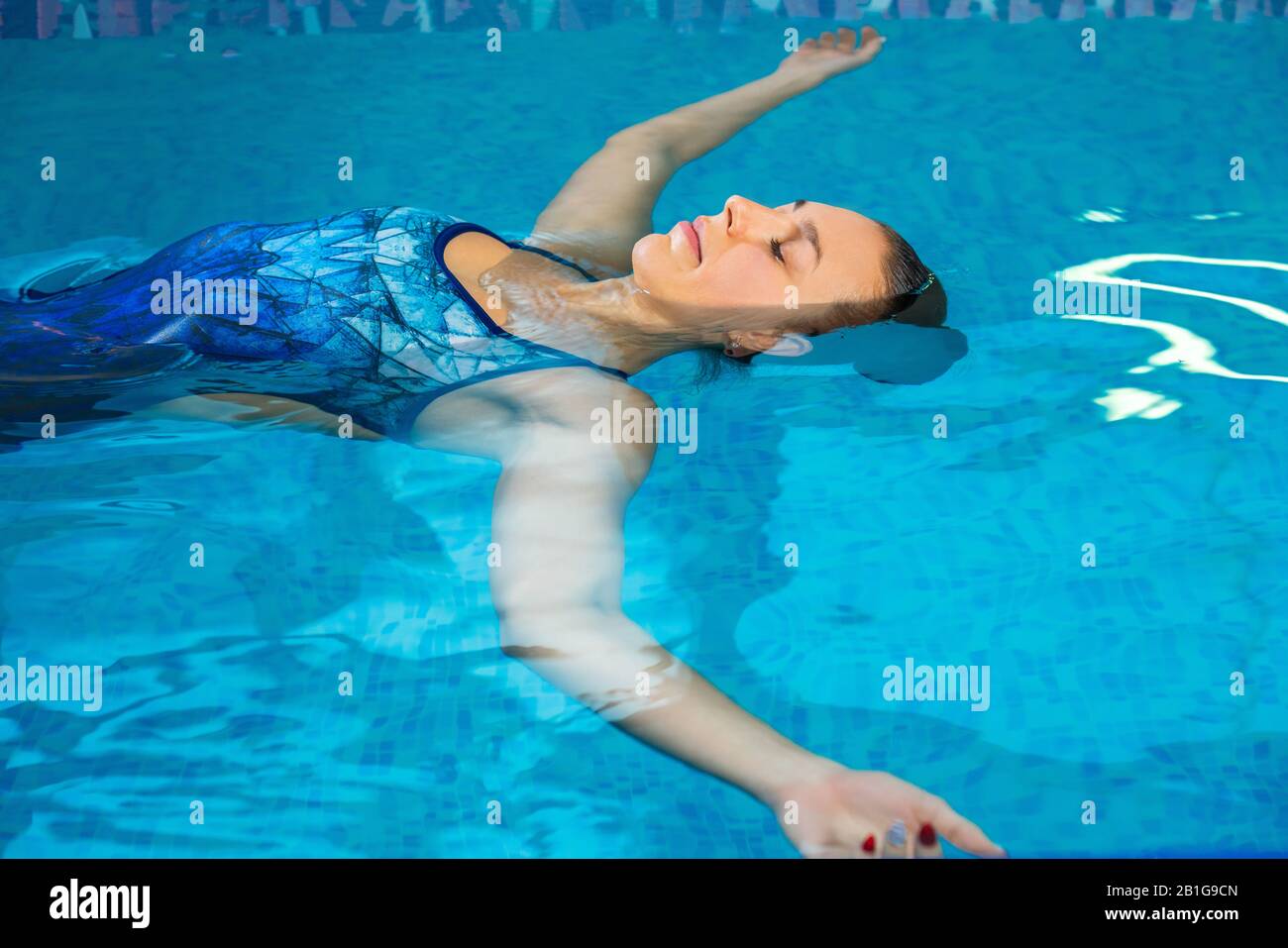 Young professional swimmer woman swimming in indoor pool Stock Photo ...