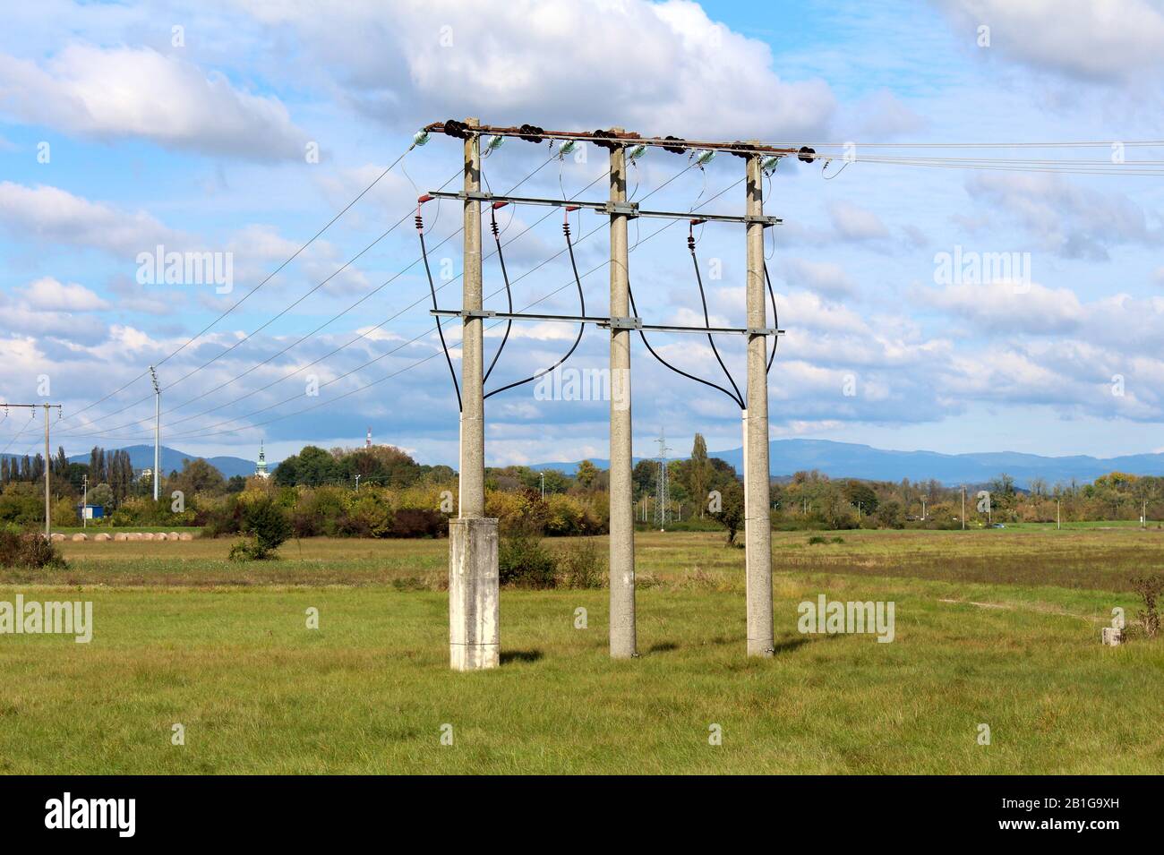Three connected large concrete power line utility poles with multiple ...