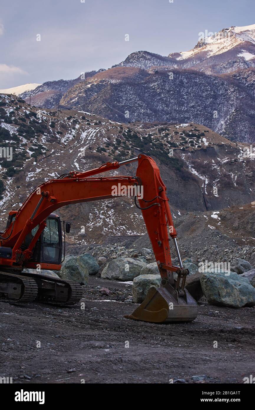 Excavator digging ground in the mountains Stock Photo - Alamy