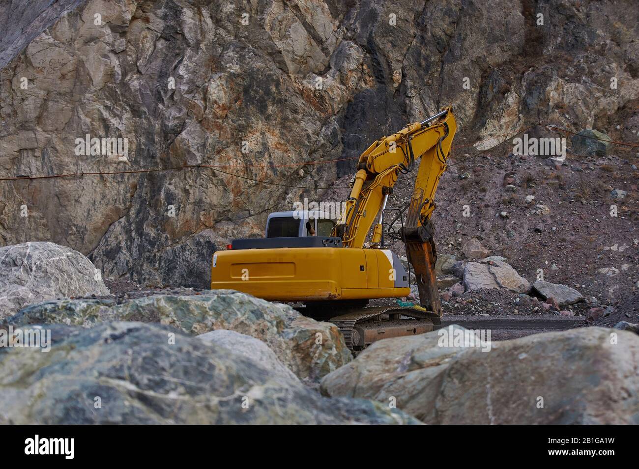 Excavator digging ground in the mountains Stock Photo - Alamy