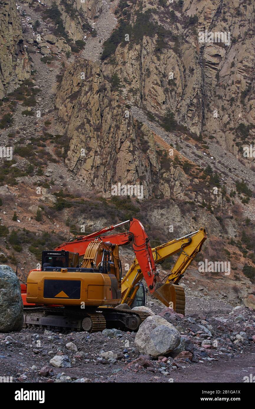 Two excavators digging ground together Stock Photo - Alamy