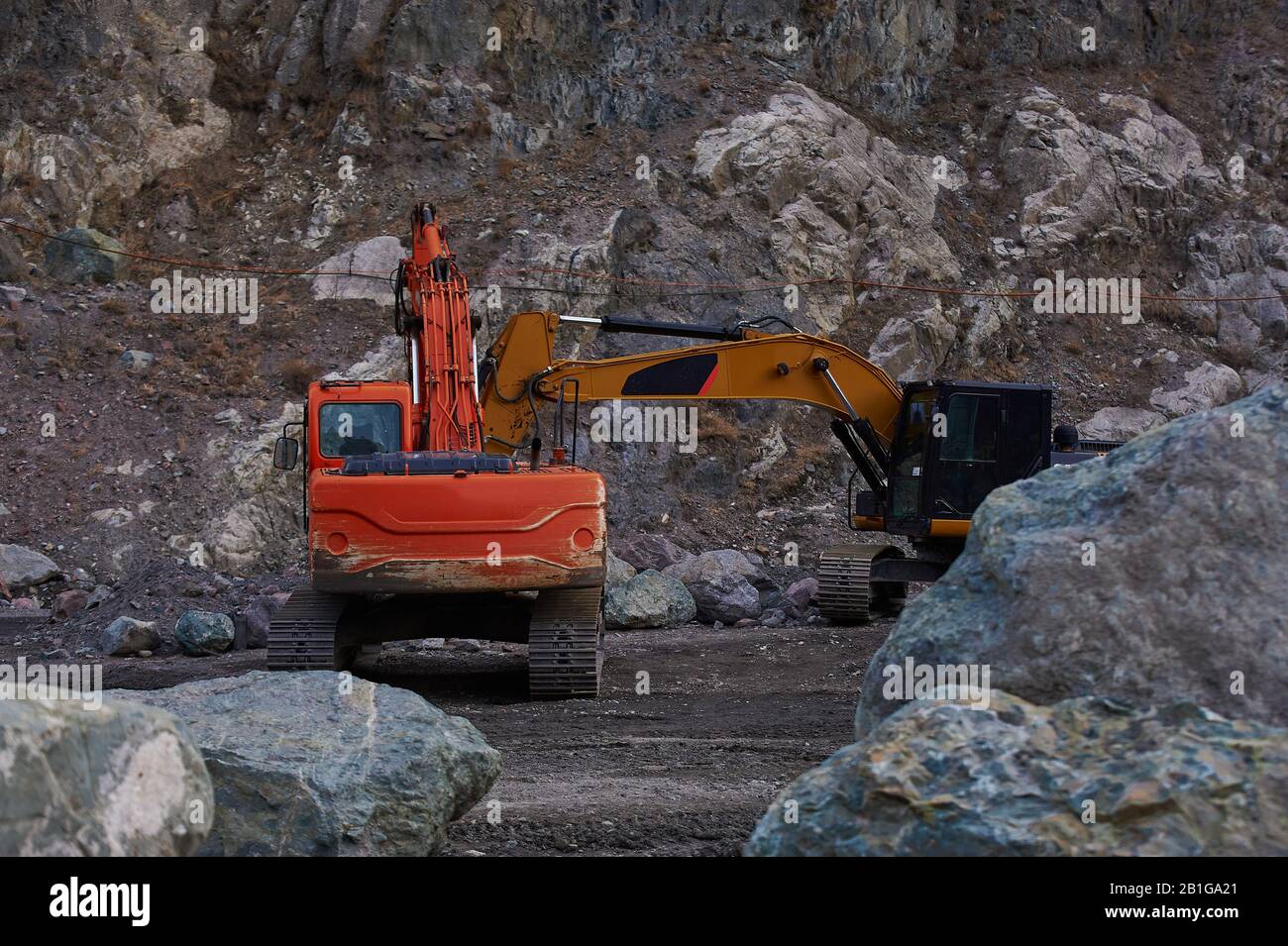 Two excavators digging ground together Stock Photo - Alamy