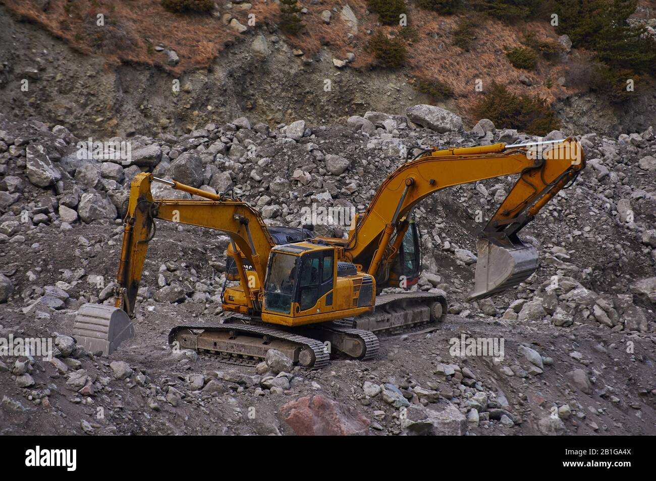 Two excavators digging ground together Stock Photo - Alamy