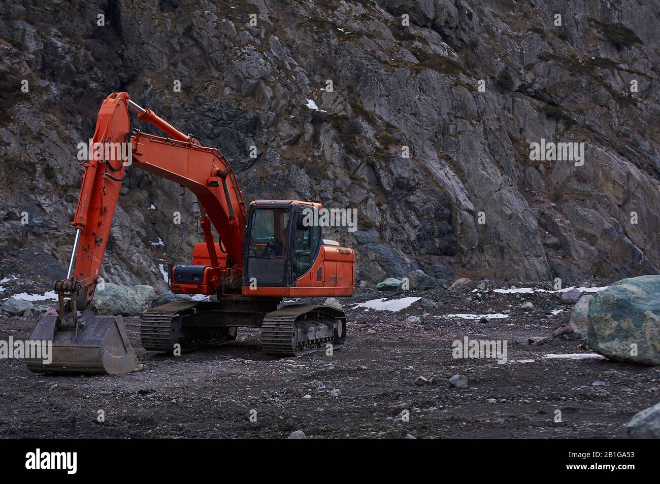 Excavator digging ground in the mountains Stock Photo - Alamy