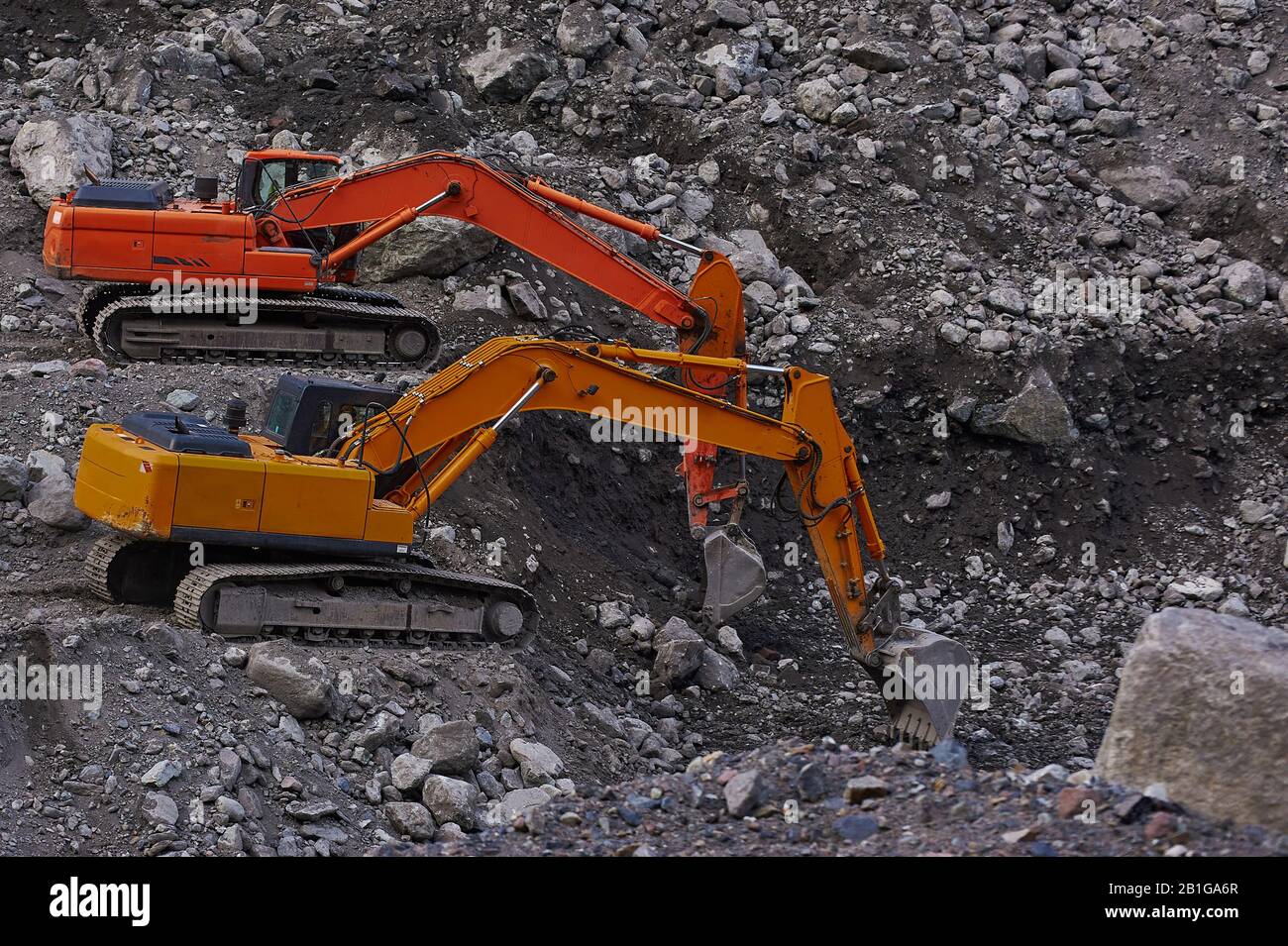 Two excavators digging ground together Stock Photo - Alamy
