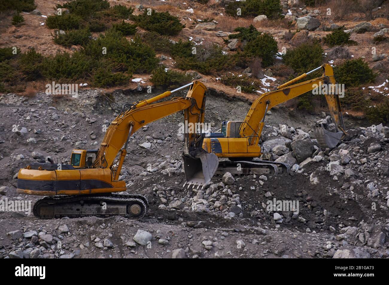 Two excavators digging ground together Stock Photo - Alamy