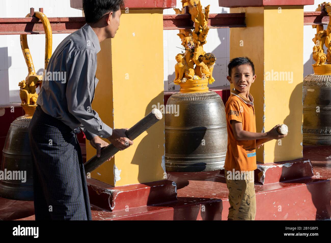 Striking ceremonial bells at Mahamuni Pagoda, Mandalay, Mandalay Region ...