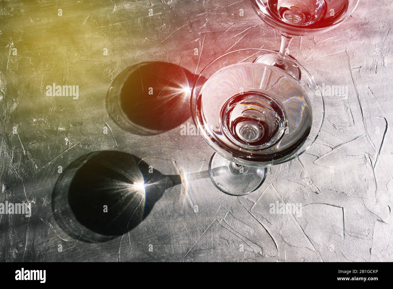 Sunlight through a cocktail glass. Reflection of glass goblets with ...