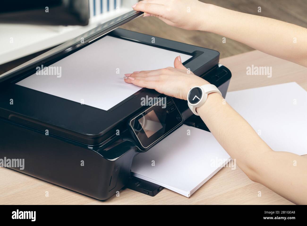 Woman making photocopy using copier in office Stock Photo - Alamy