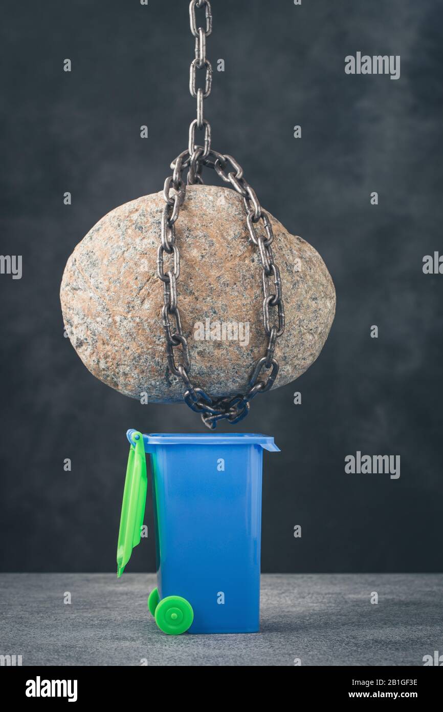 Stone hanging above trash can Stock Photo - Alamy