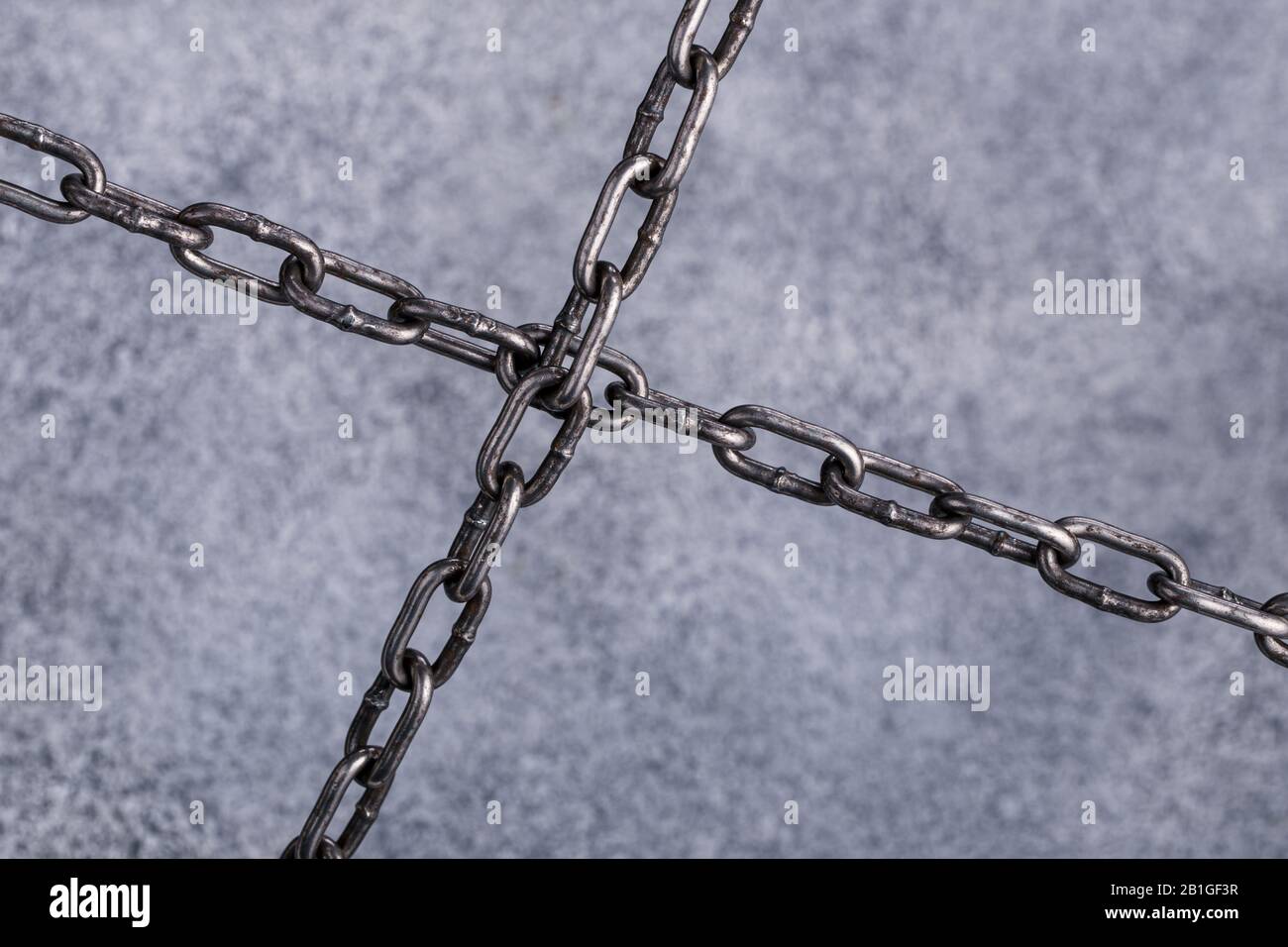 Two crossed chains on gray Stock Photo - Alamy