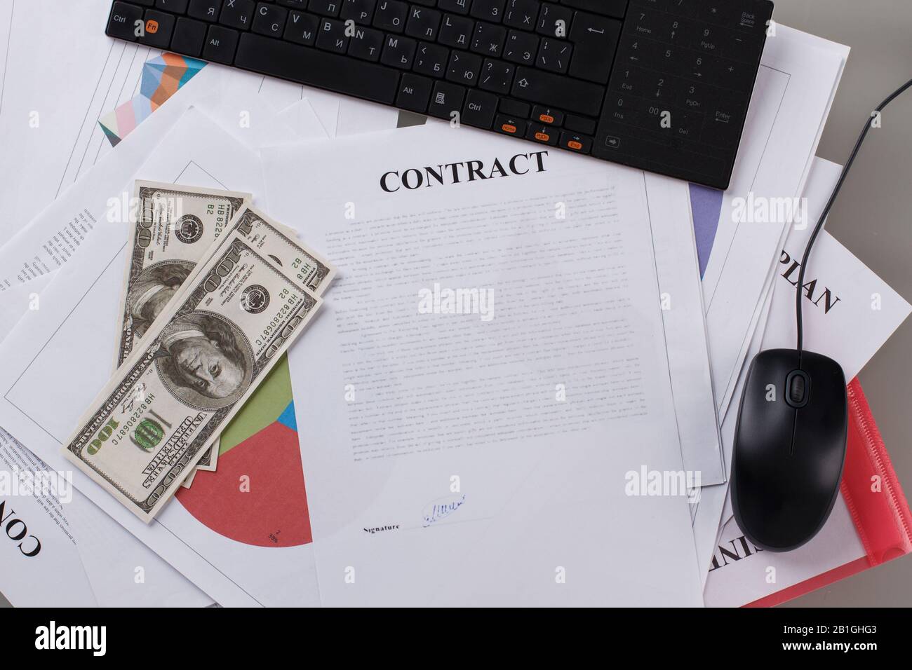 Signed contract on table with dollar banknotes Stock Photo - Alamy
