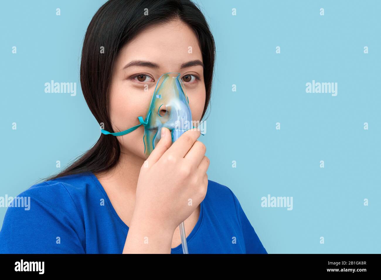 Freestyle. Chinese woman in oxygen mask standing isolated on grey ...