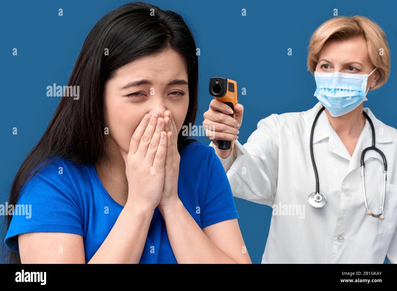 Middle aged doctor checking temperature at patient with infrared tool ...