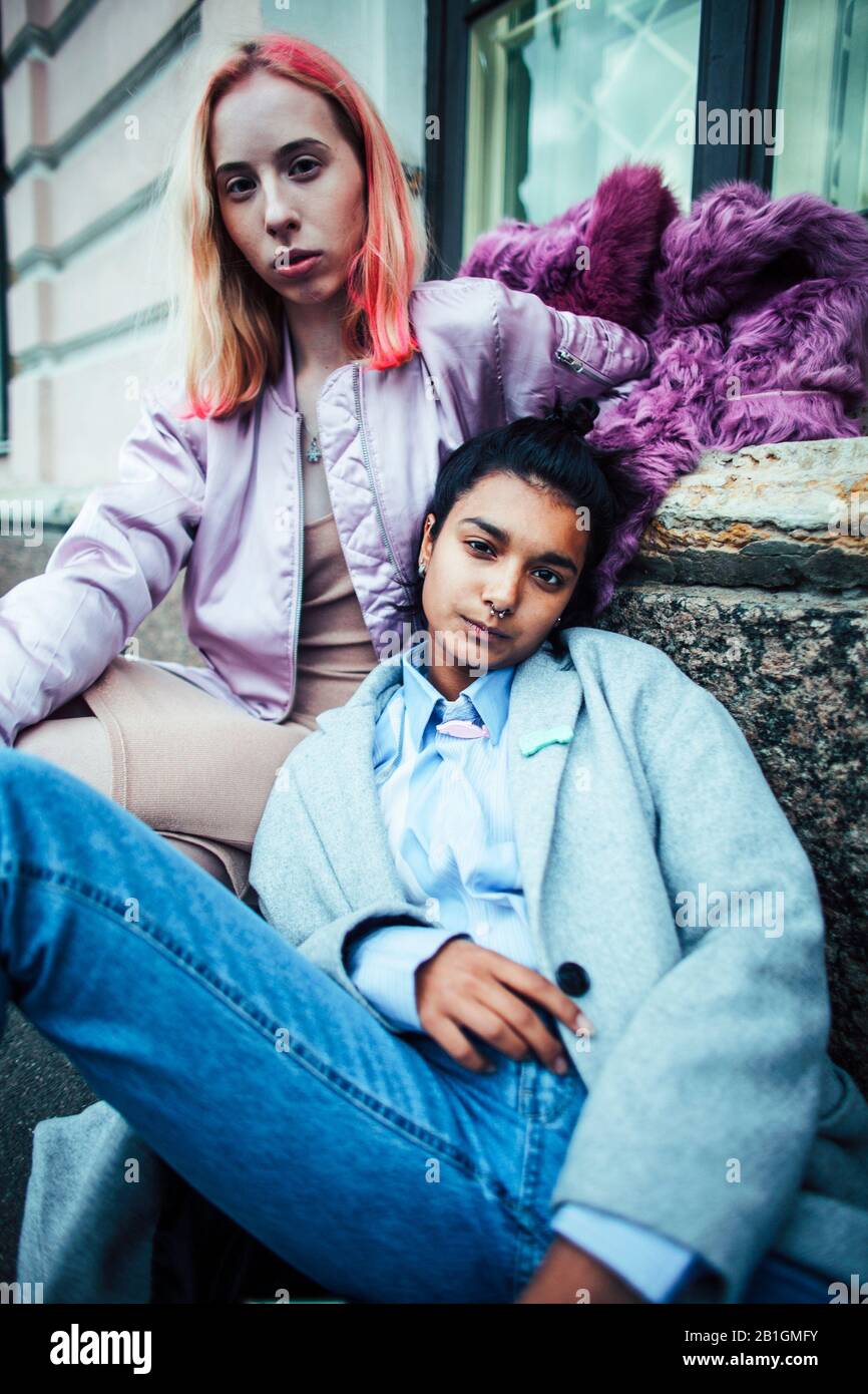 Two teenage girls infront of university building smiling, having fun ...