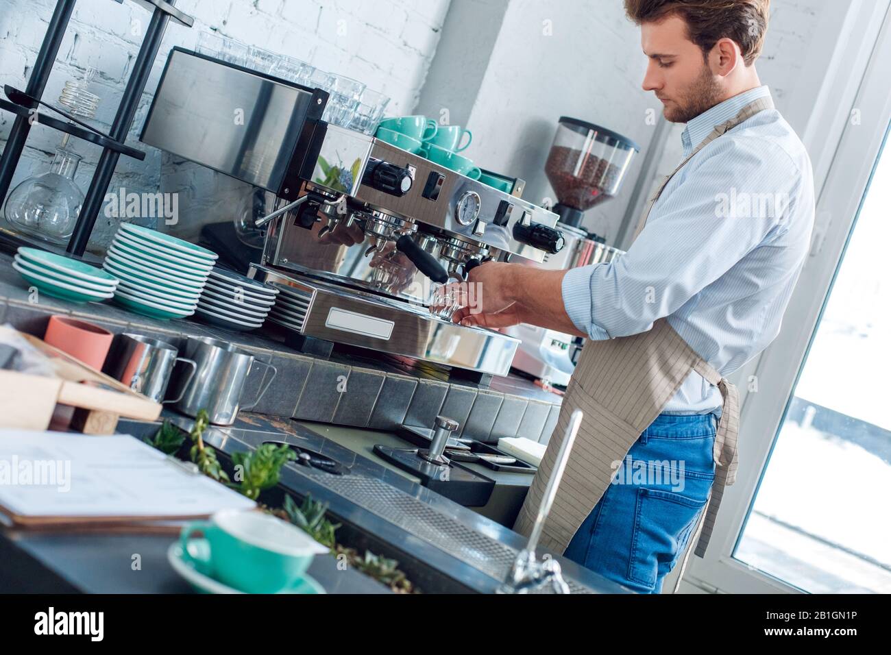 Coffee Passion. Young barista at coffee shop making espresso shot ...