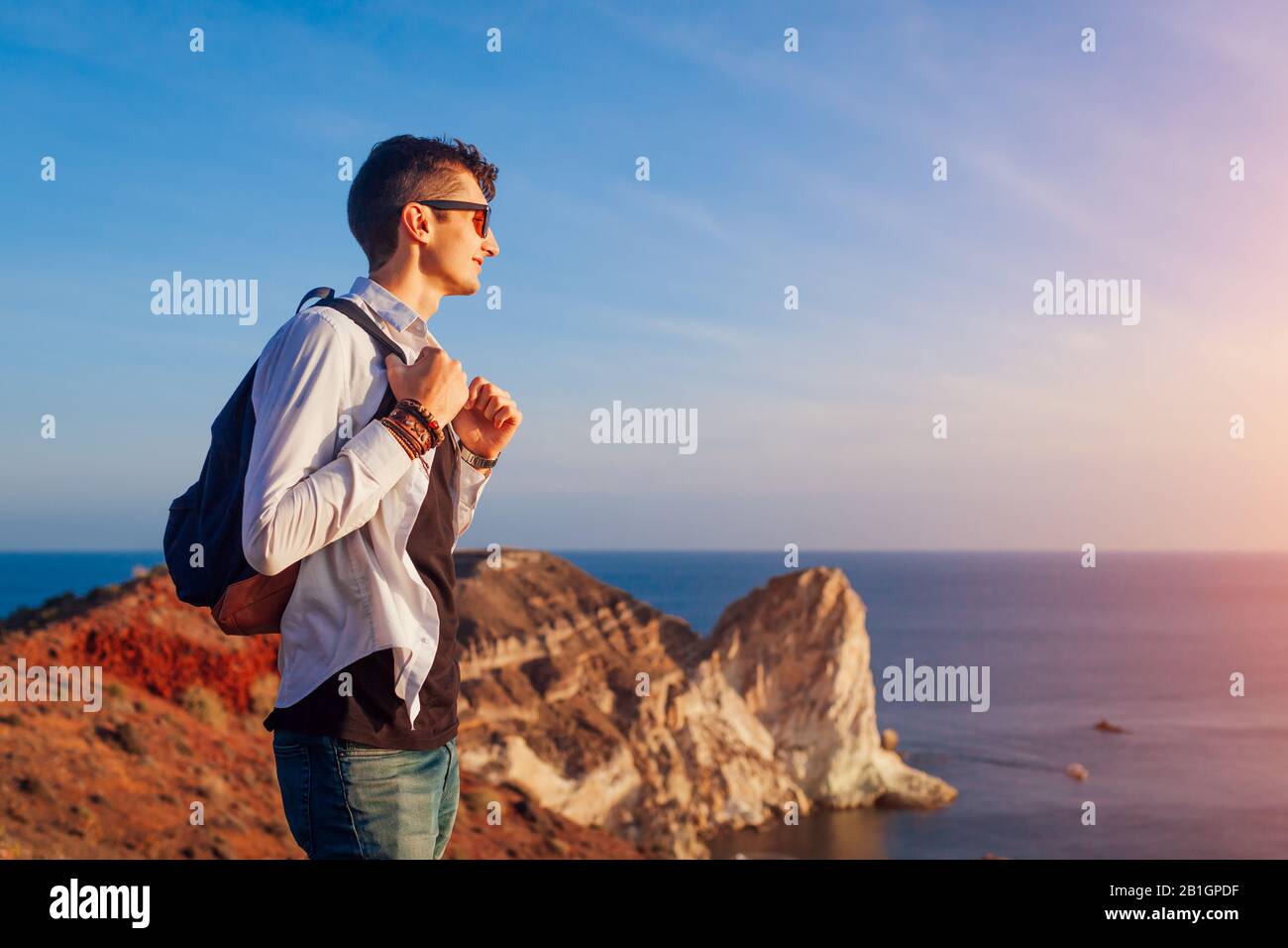 Tourist walking by White beach on Aegean sea Santorini island Greece ...